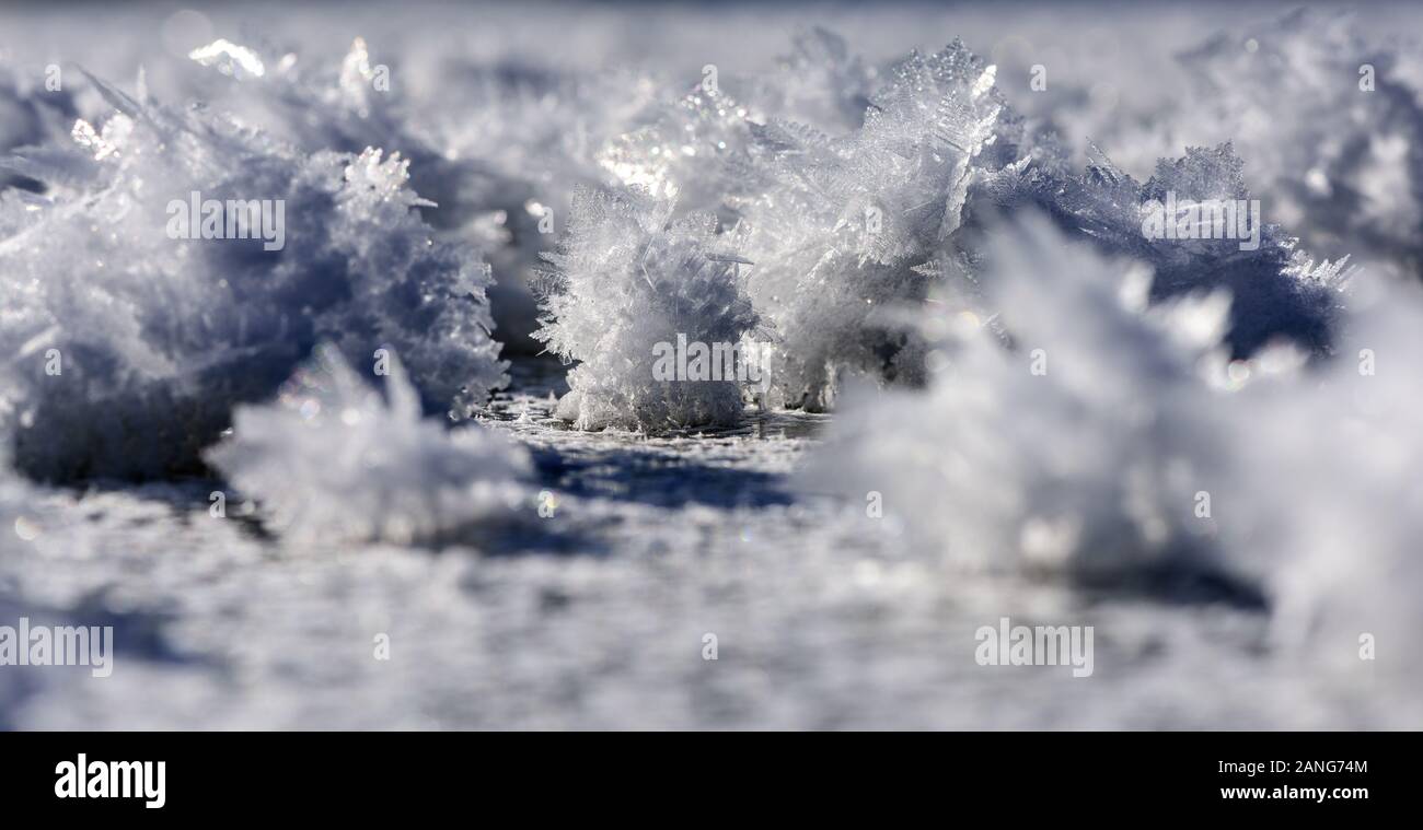 Real frozen ice crystals in blue, winter background. Closeup of ice ...