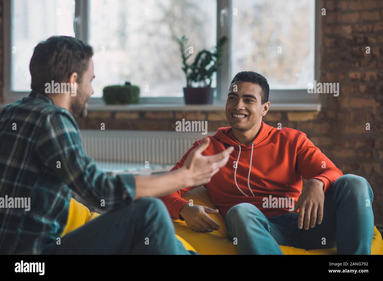 Two friends talking listening indoors hi-res stock photography and ...