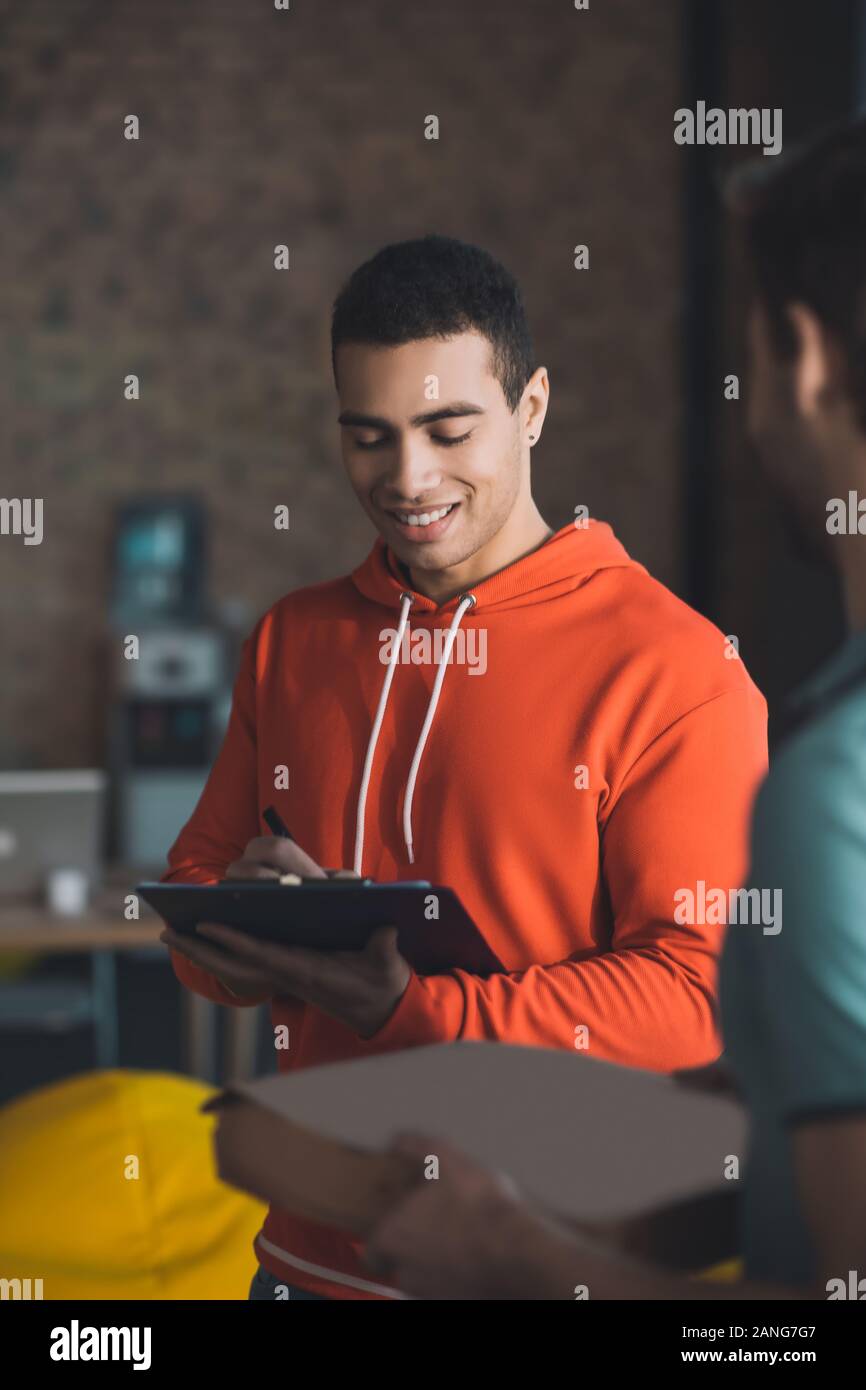 Joyful good looking man receiving the delivery Stock Photo - Alamy
