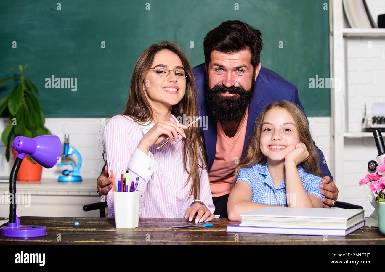 Extra classes. Gifted child. Little girl studying with team of tutors ...