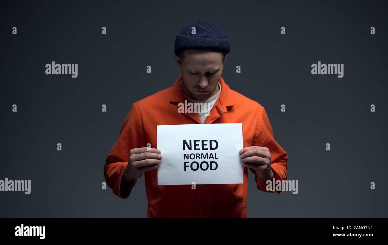 Male prisoner holding Need normal food sign, ill treatment in jail ...