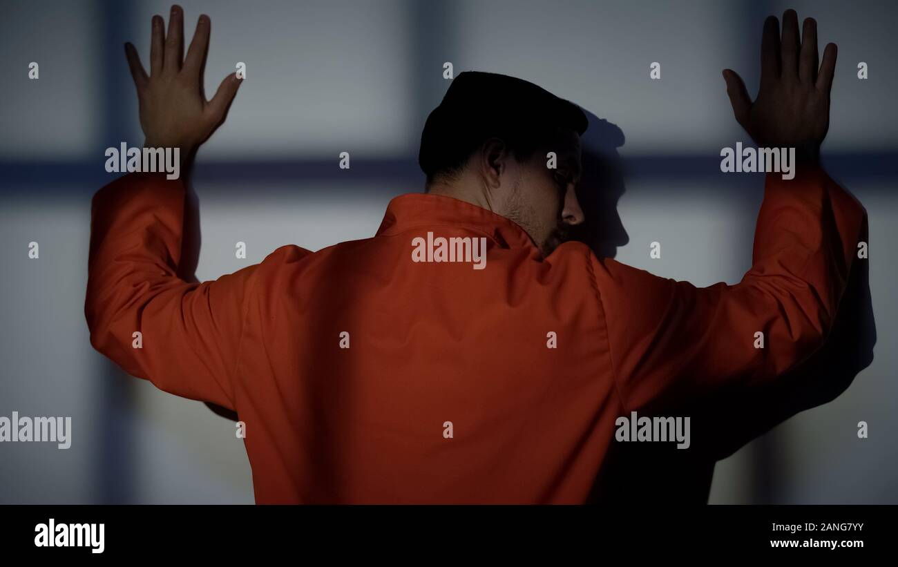 Male prisoner standing face to wall, security check-up in jail ...