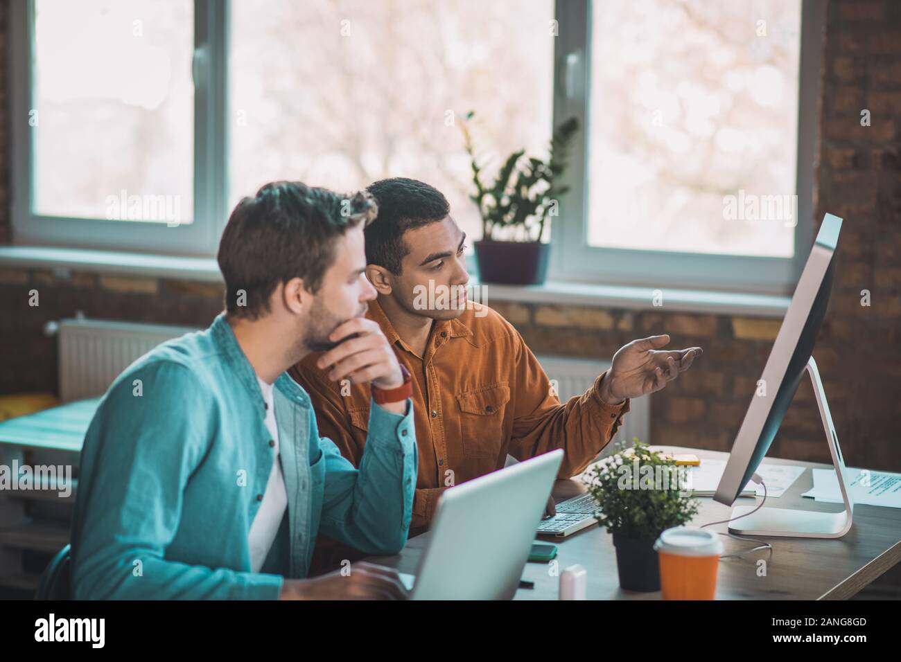 Nice young man pointing at the computer screen Stock Photo - Alamy