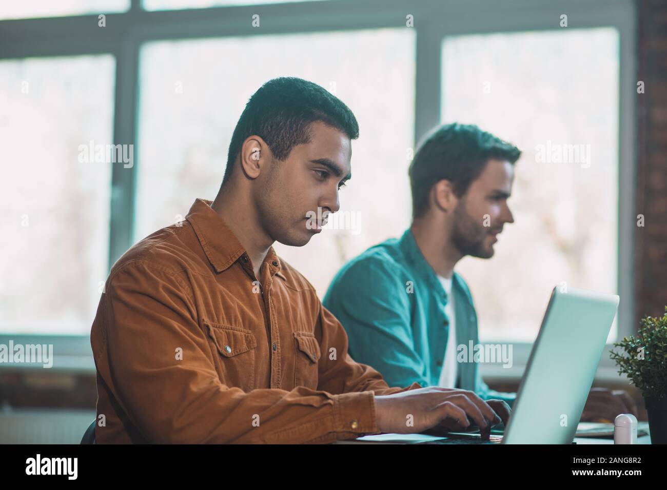 Smart young man concentrating on his job Stock Photo - Alamy