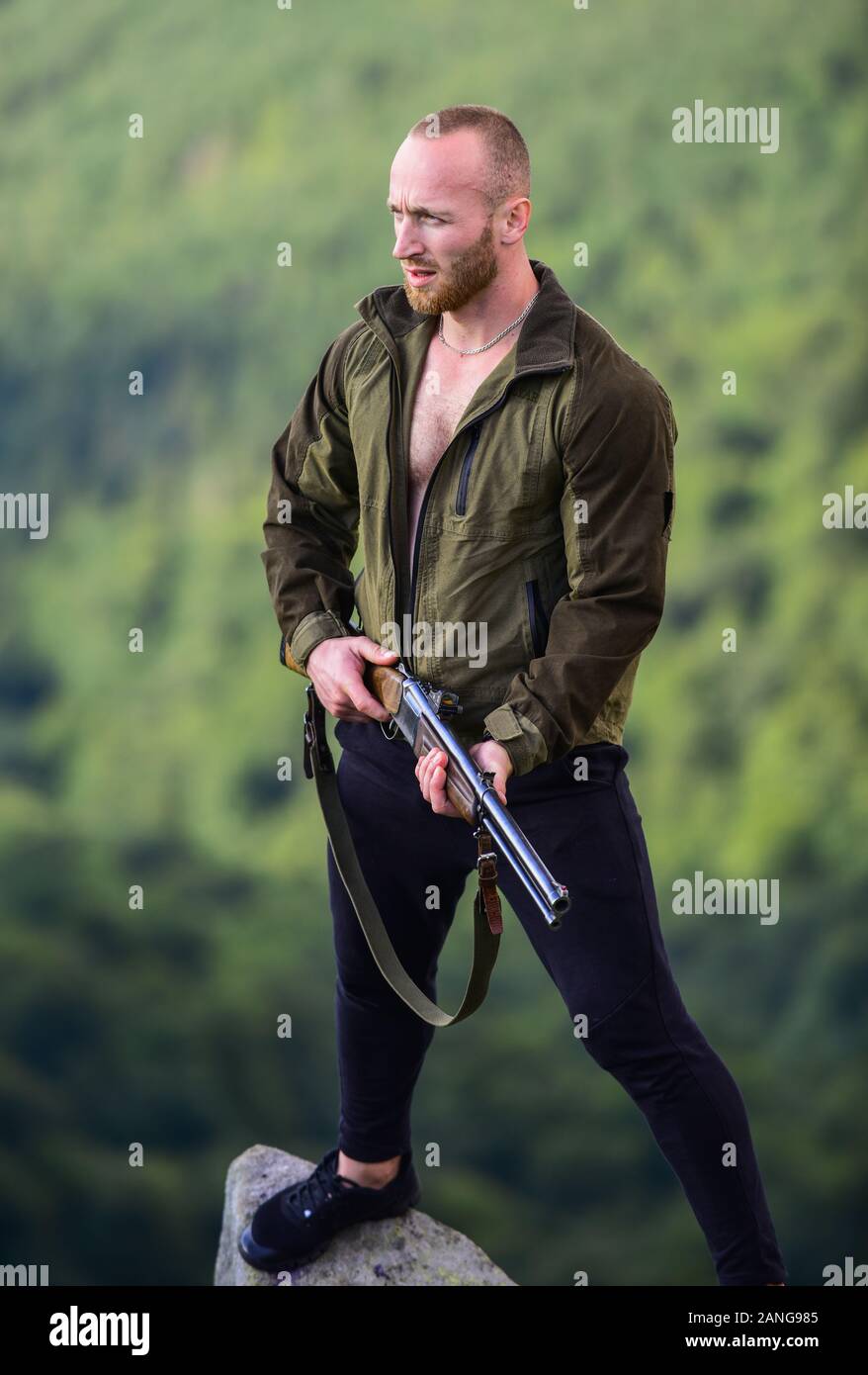 Man brutal poacher with weapon natural landscape background. Hunter ...