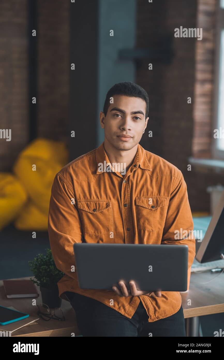 Handsome smart man standing with his laptop Stock Photo - Alamy
