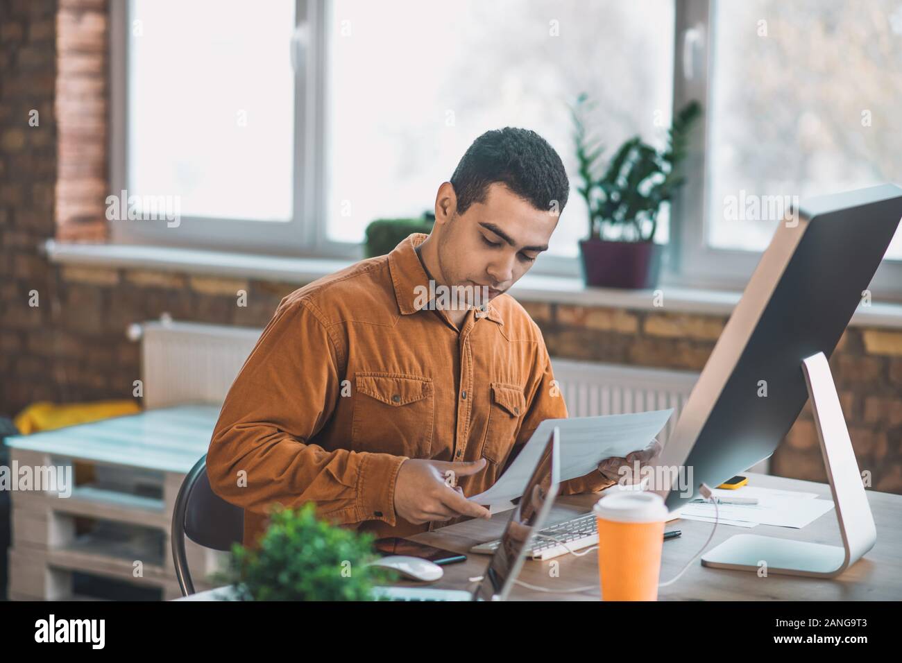 Nice serious young man focusing on his project Stock Photo - Alamy