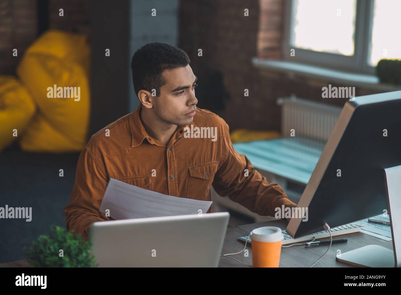 Smart concentrated young man working in the office Stock Photo - Alamy
