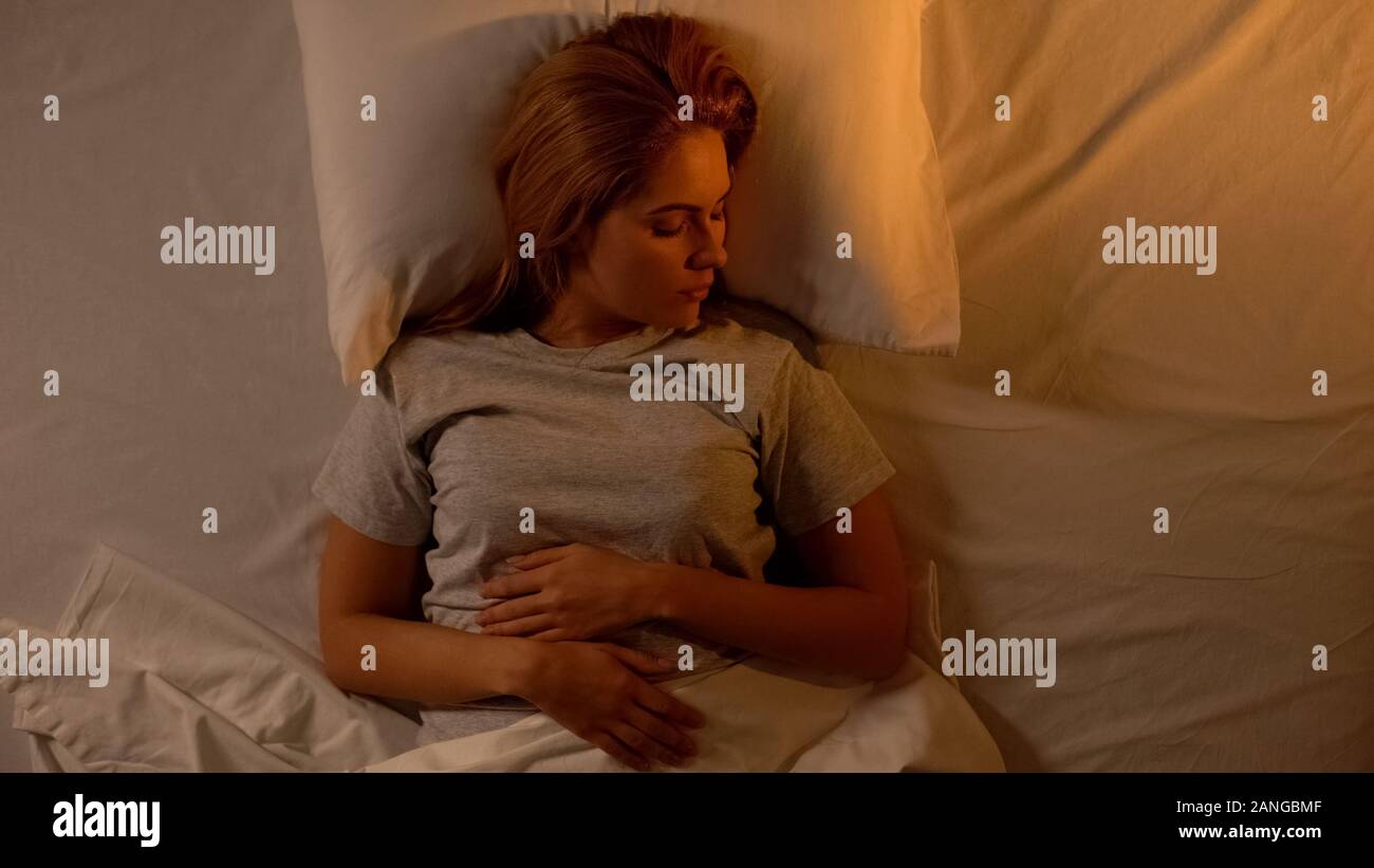 Beautiful female peacefully sleeping in white bed, good sleeping ...