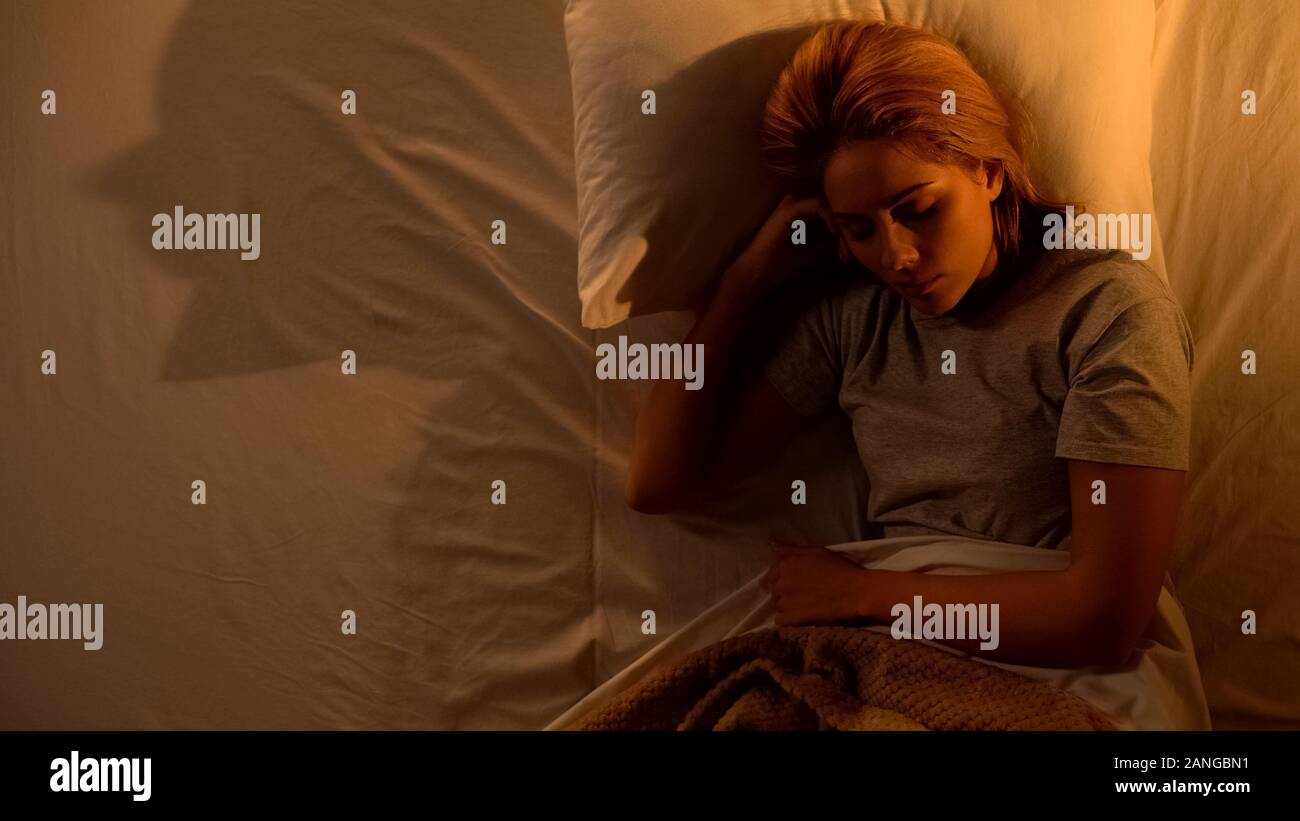 Single female sleeping in bed, suffering nightmares, monster shaped ...