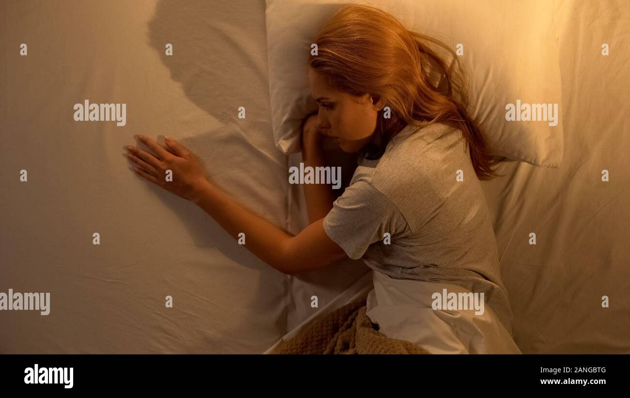 Woman crying touching empty side of bed, loss of beloved, depression ...