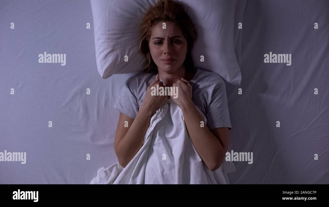 Attractive woman crying lying in bed at night, female weakness and ...