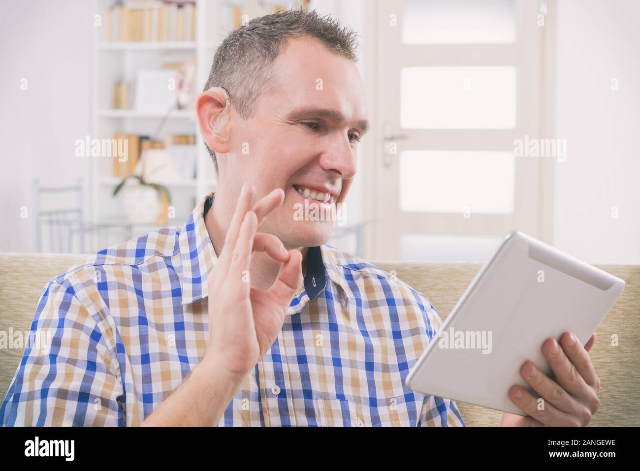 Smiling Deaf man talking using sign language on the tablets's cam Stock ...