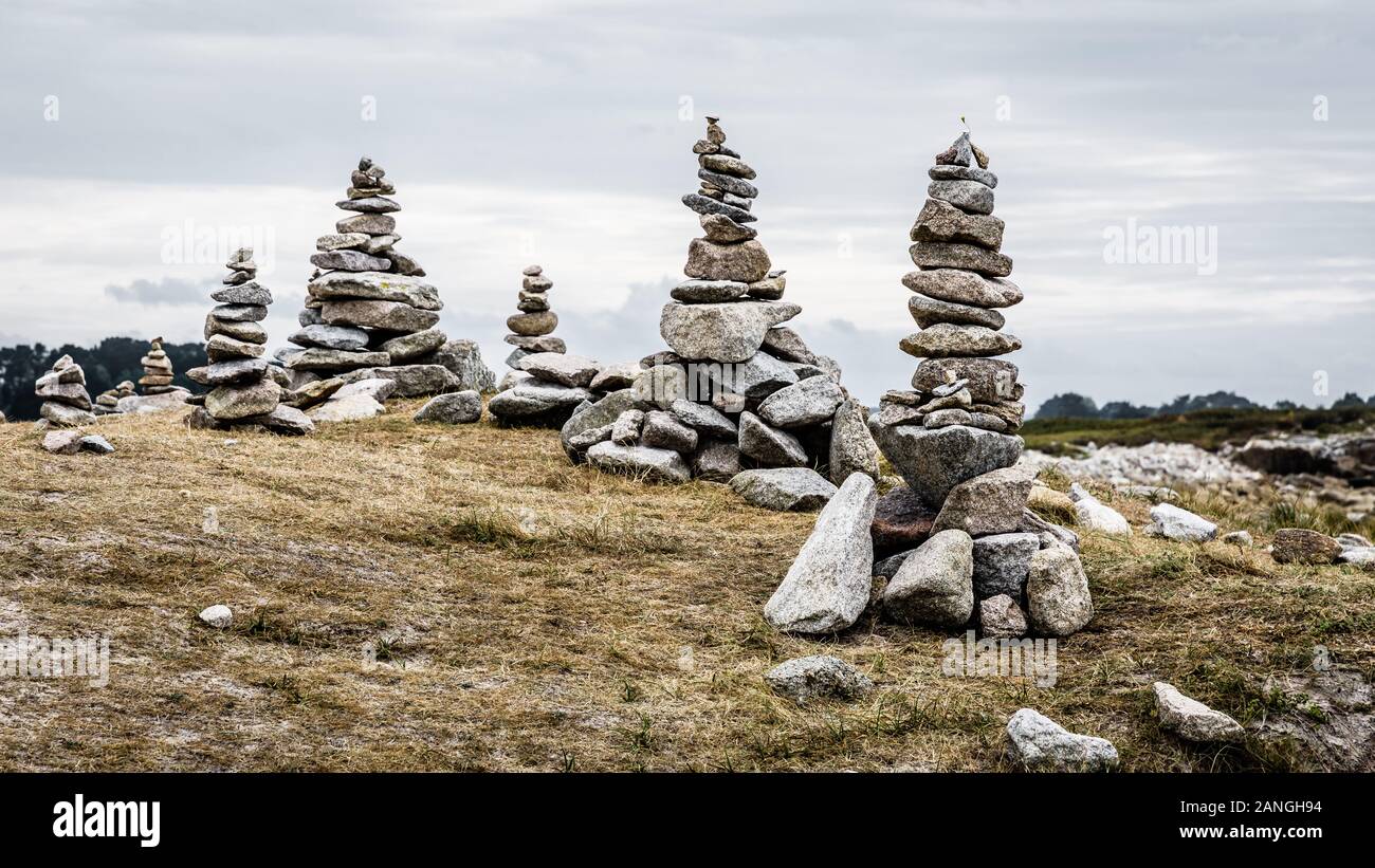 Several man-made granite stone stacks (called cairns) on the coastal path in Brittany, France ...
