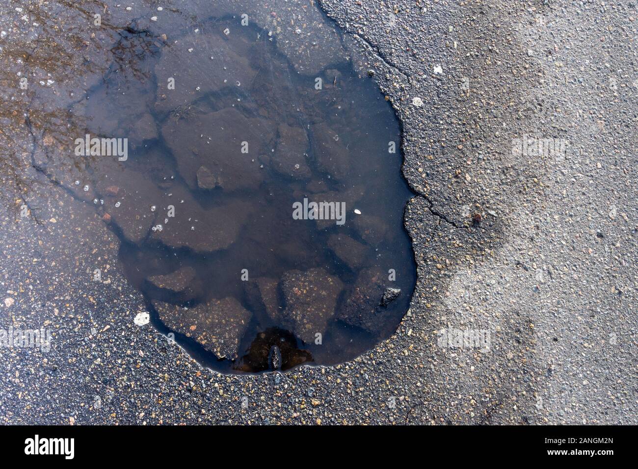 road pothole flooded with board water, close-up. Background a texture ...