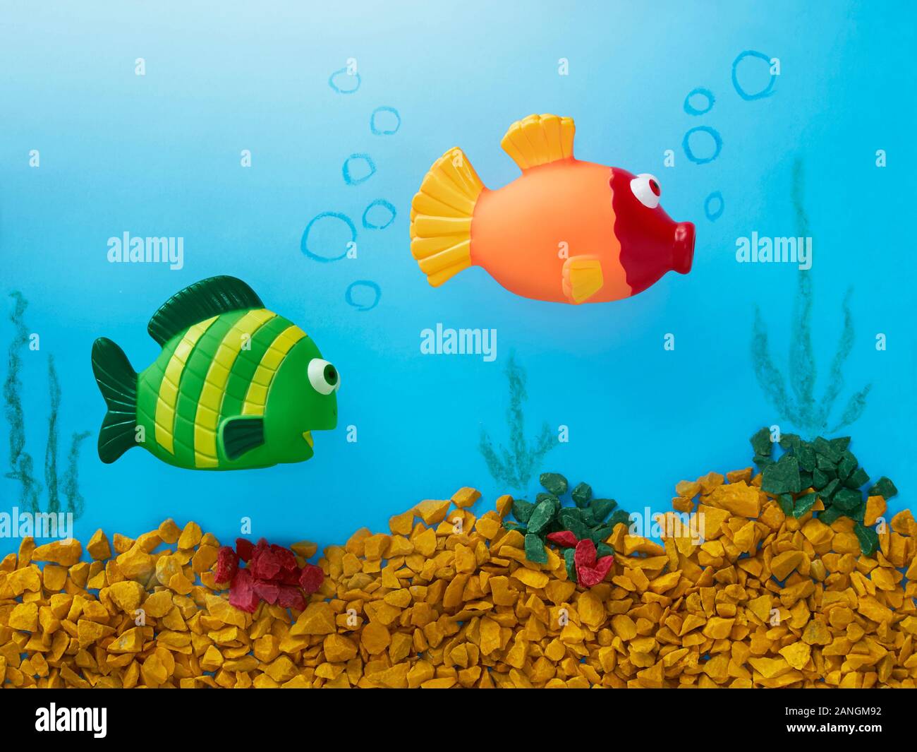 Two colourful fish toys with blue background Stock Photo - Alamy