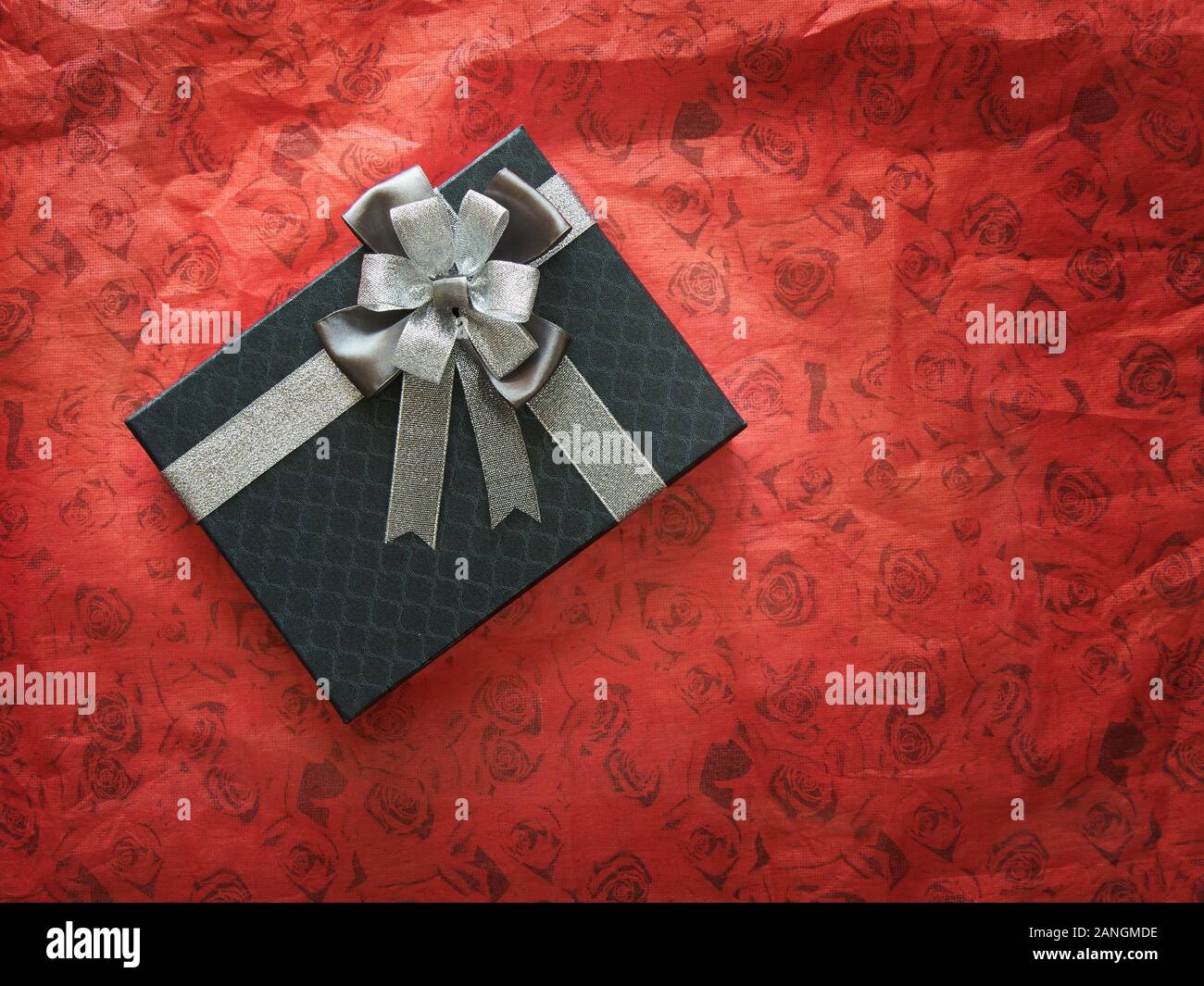 A grey box with grey ribbon on the red background flowering Stock Photo ...