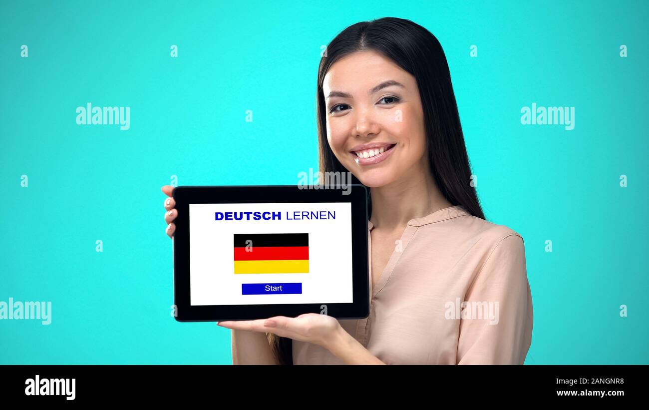 Female holding tablet with learn german application, ready to start ...