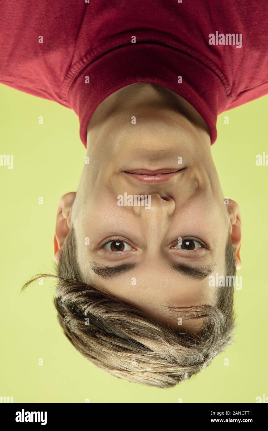 Smiling cute, looks happy. Inverted portrait of caucasian young man on ...