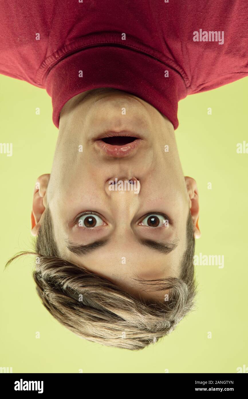 Looks shocked, astonished. Inverted portrait of caucasian young man on ...