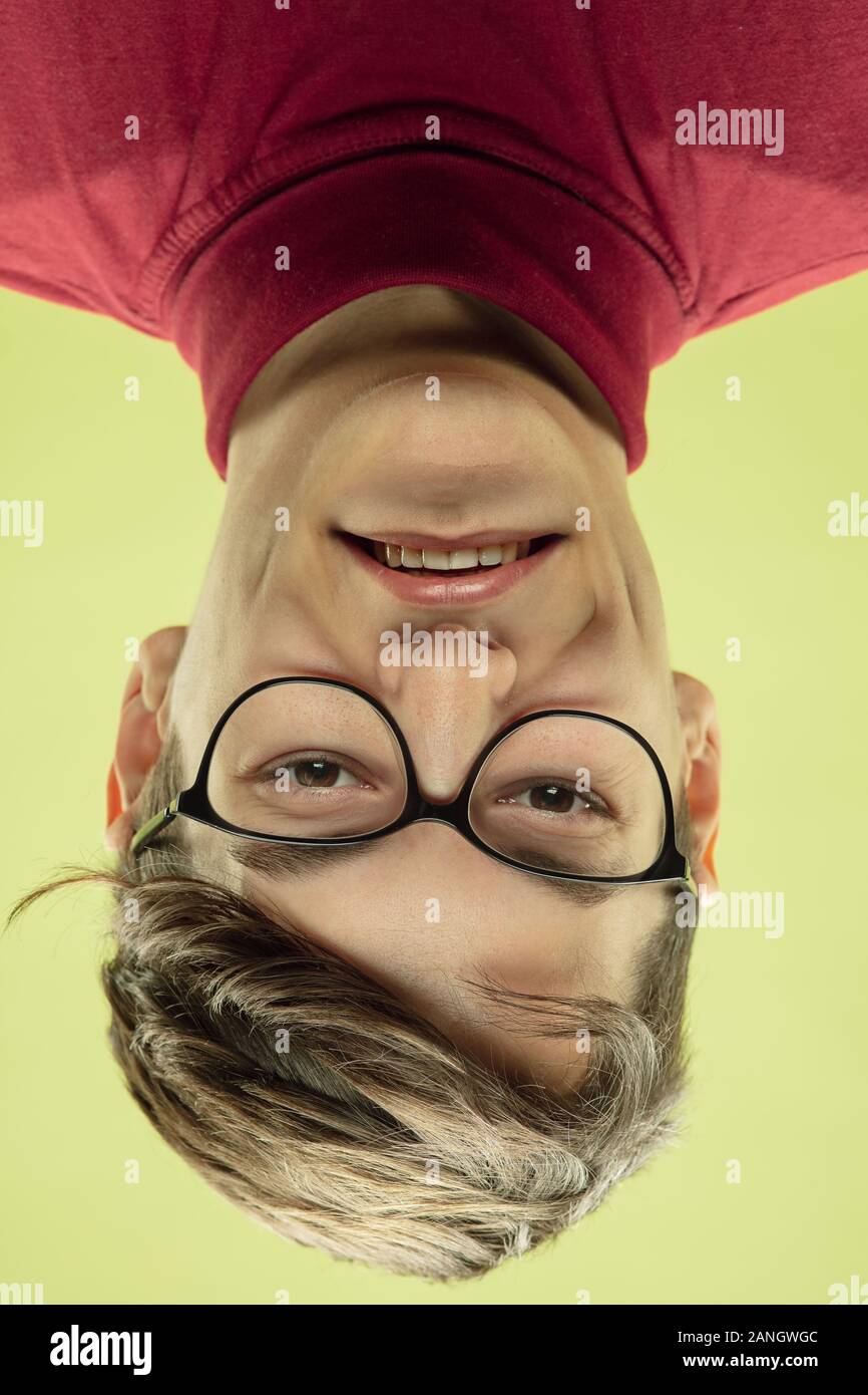 Smiling cute, looks happy. Inverted portrait of caucasian young man on ...