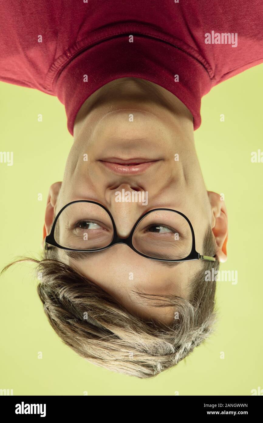 Smiling cute, looks happy. Inverted portrait of caucasian young man on ...
