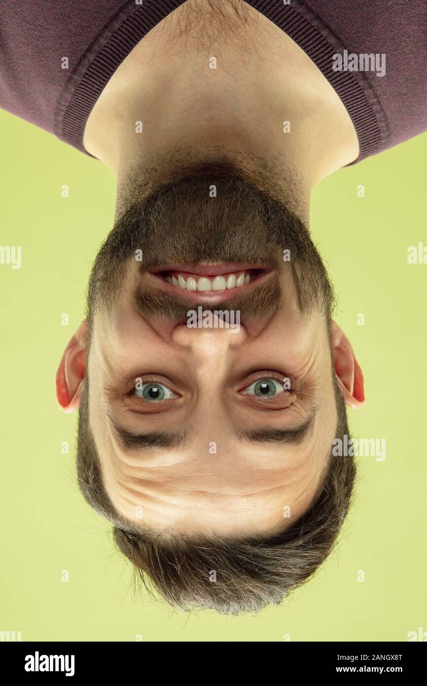 Looks happy, smiling. Inverted portrait of caucasian young man on ...