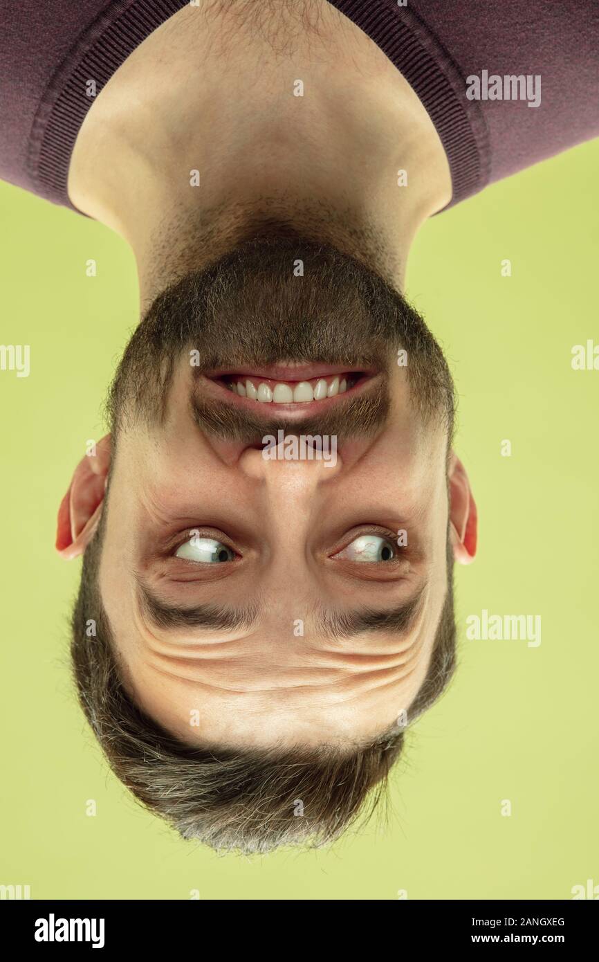 Looks happy, smiling. Inverted portrait of caucasian young man on ...