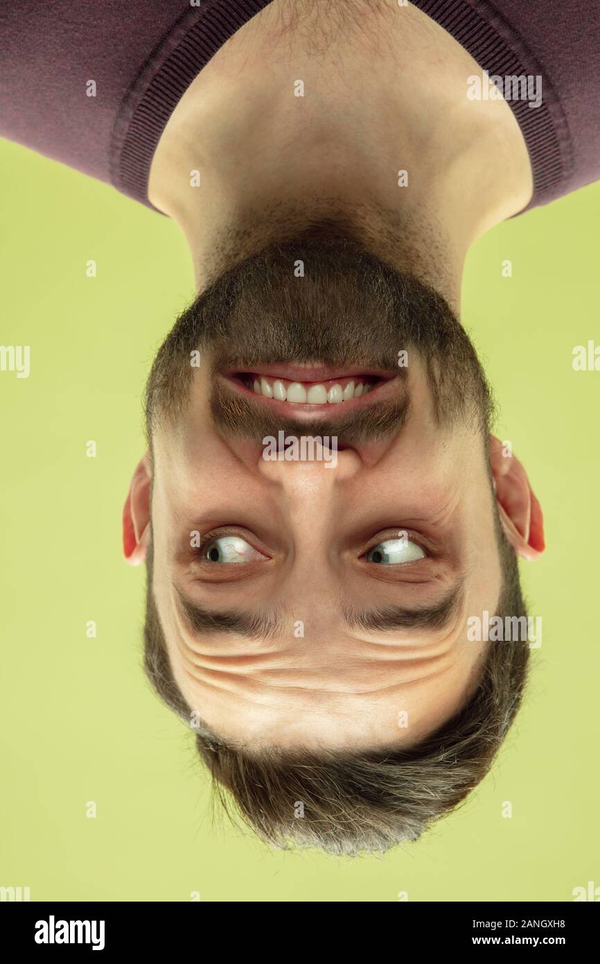 Looks happy, smiling. Inverted portrait of caucasian young man on ...