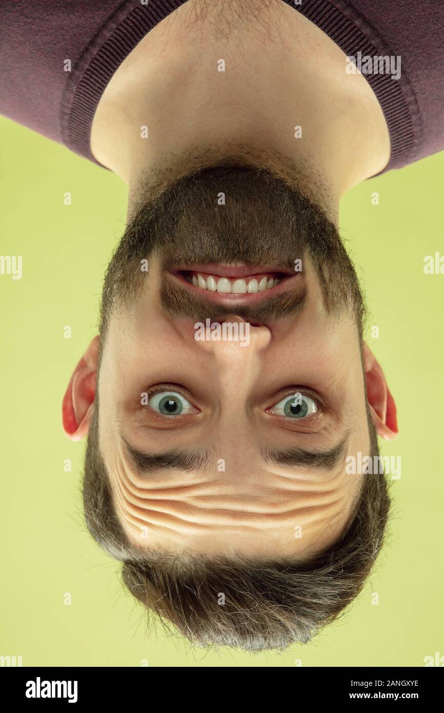 Looks happy, smiling. Inverted portrait of caucasian young man on ...