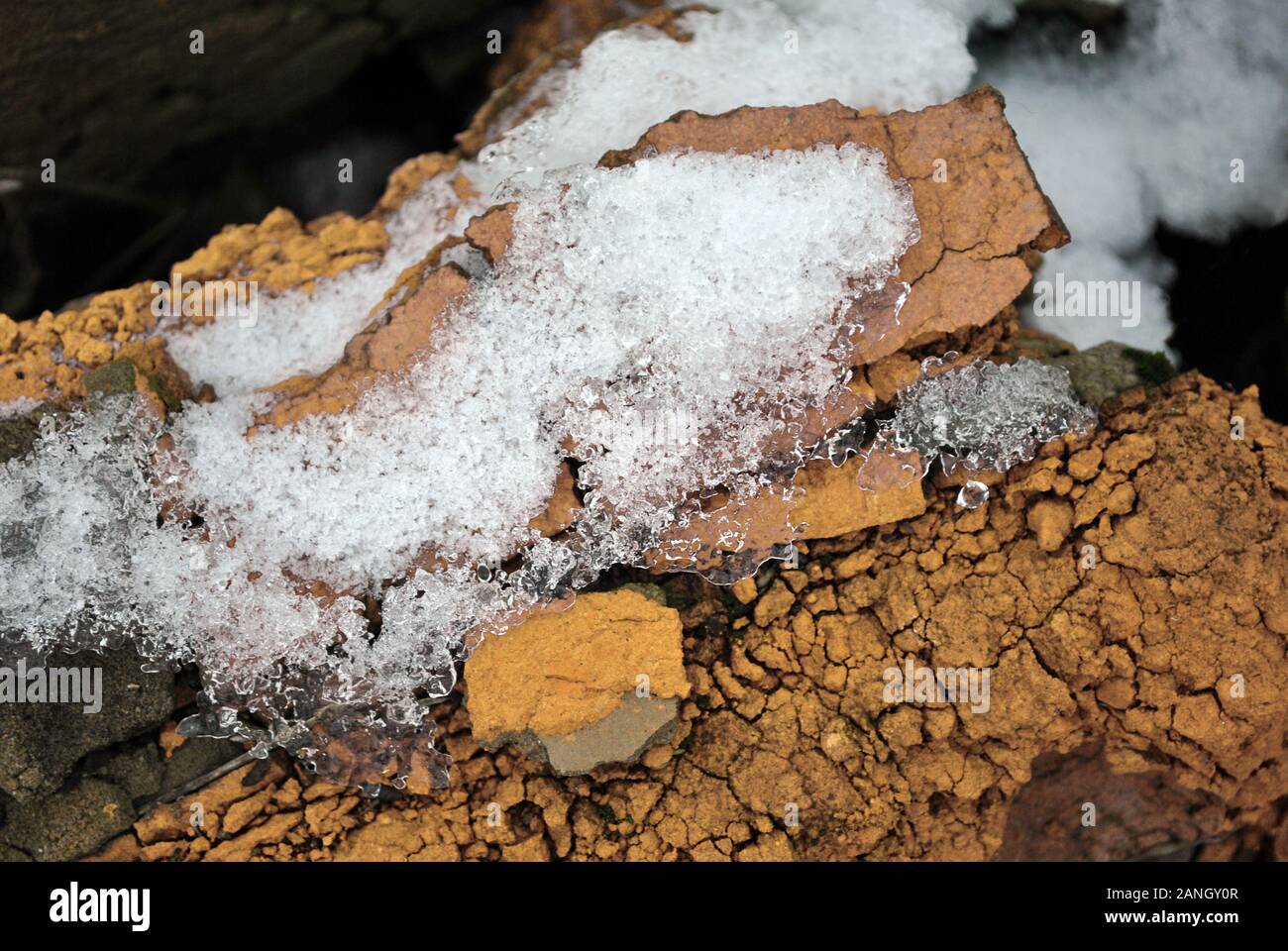 Melting snow on crumbling wall of red bricks, grunge background Stock ...
