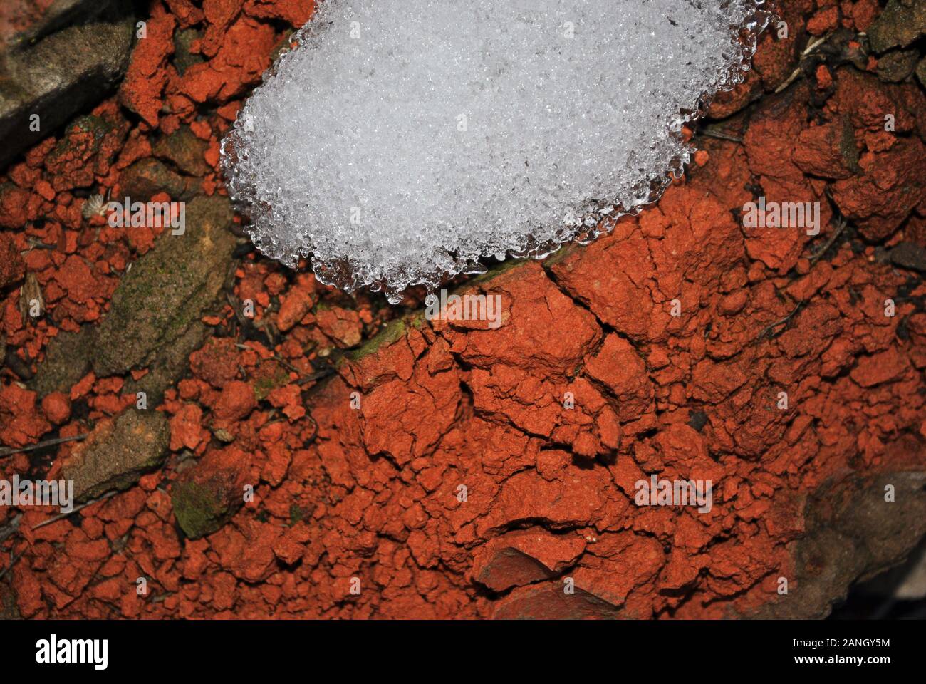 Melting snow on crumbling wall of red bricks, grunge background Stock ...