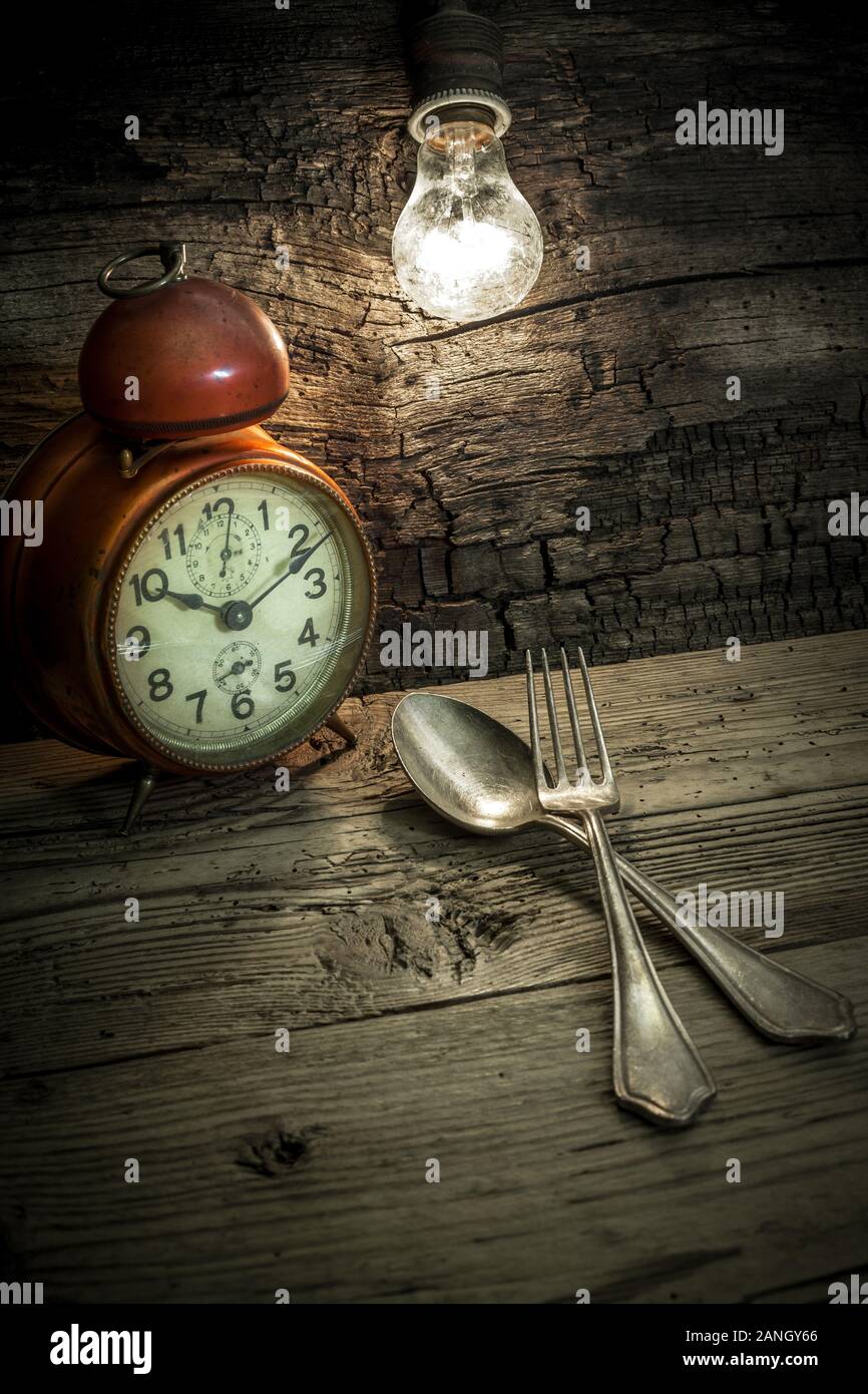 old alarm clock with incandescent light bulb Stock Photo - Alamy