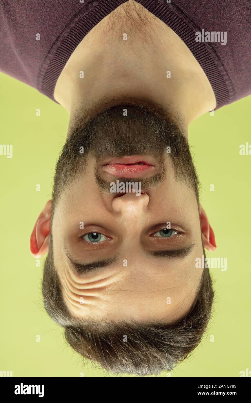 Disgusting, upset. Inverted portrait of caucasian young man on yellow ...