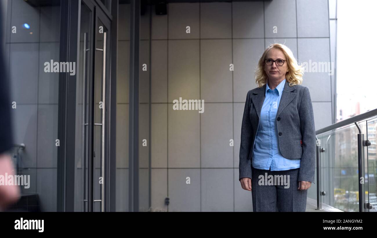 Strict female boss looking at company employee, irritated head of ...