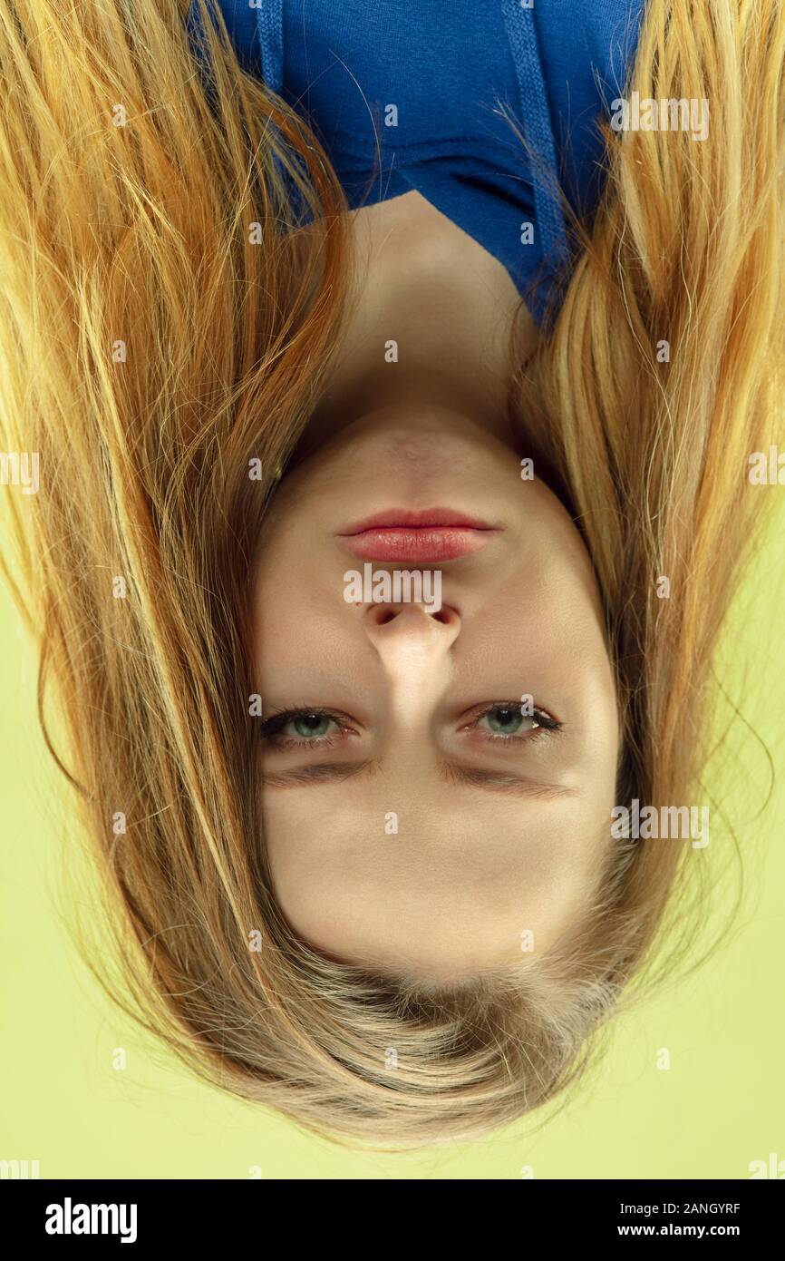 Sad, upset, angry. Inverted portrait of caucasian young woman on yellow ...