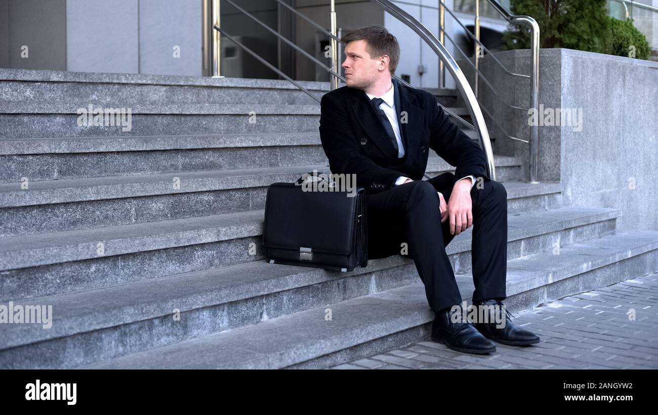 Upset dismissed employee looking office building, unemployment stress ...