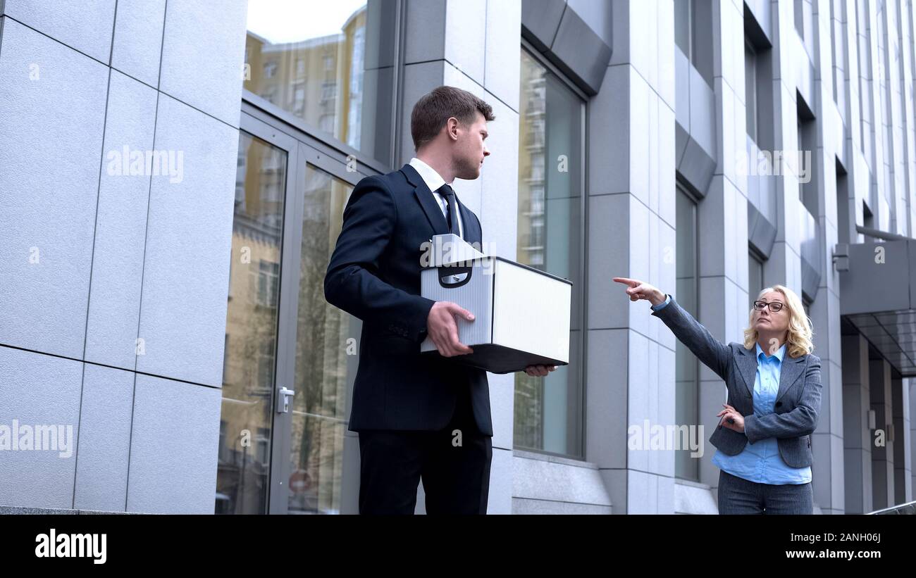 Strict business lady pointing exit, male assistant dismissal, work ...