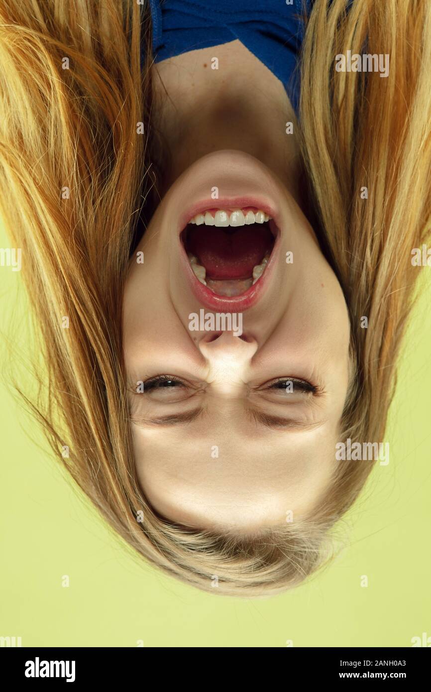 Screaming, calling. Inverted portrait of caucasian young woman on ...