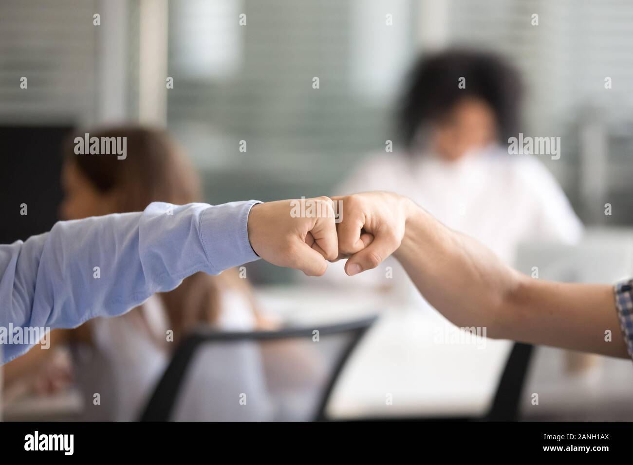 Close up of male colleagues give fists bump celebrating successful ...