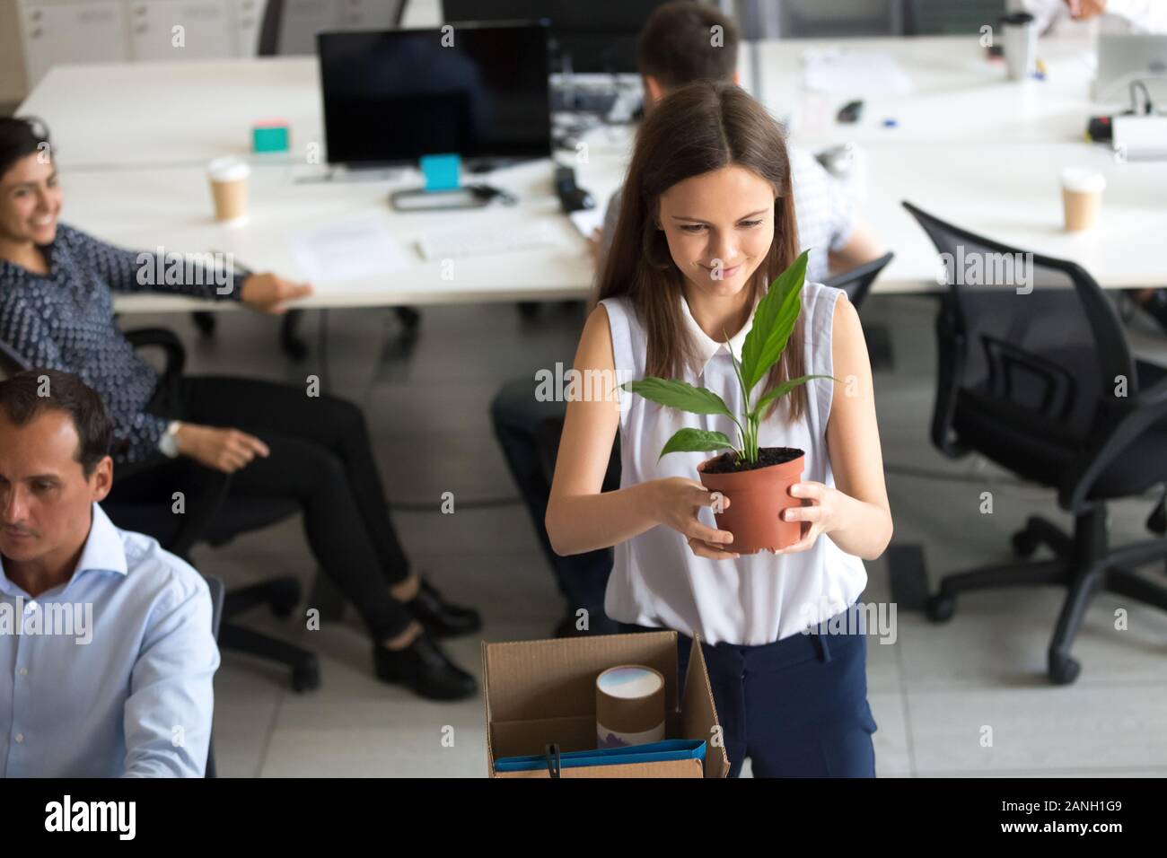 Excited millennial female worker unpack personal belongings on first ...