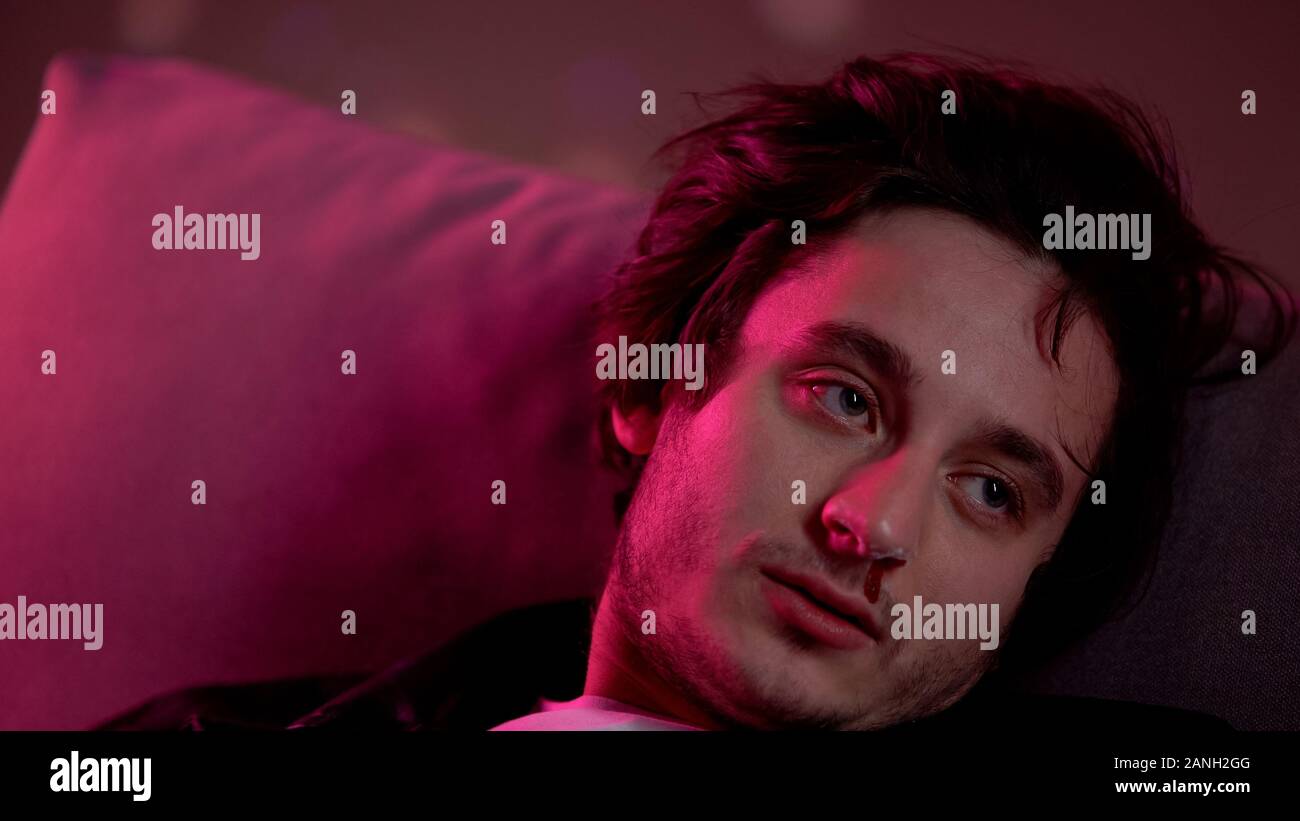 Cocaine addict man with bloody nose sitting at coach in nightclub ...