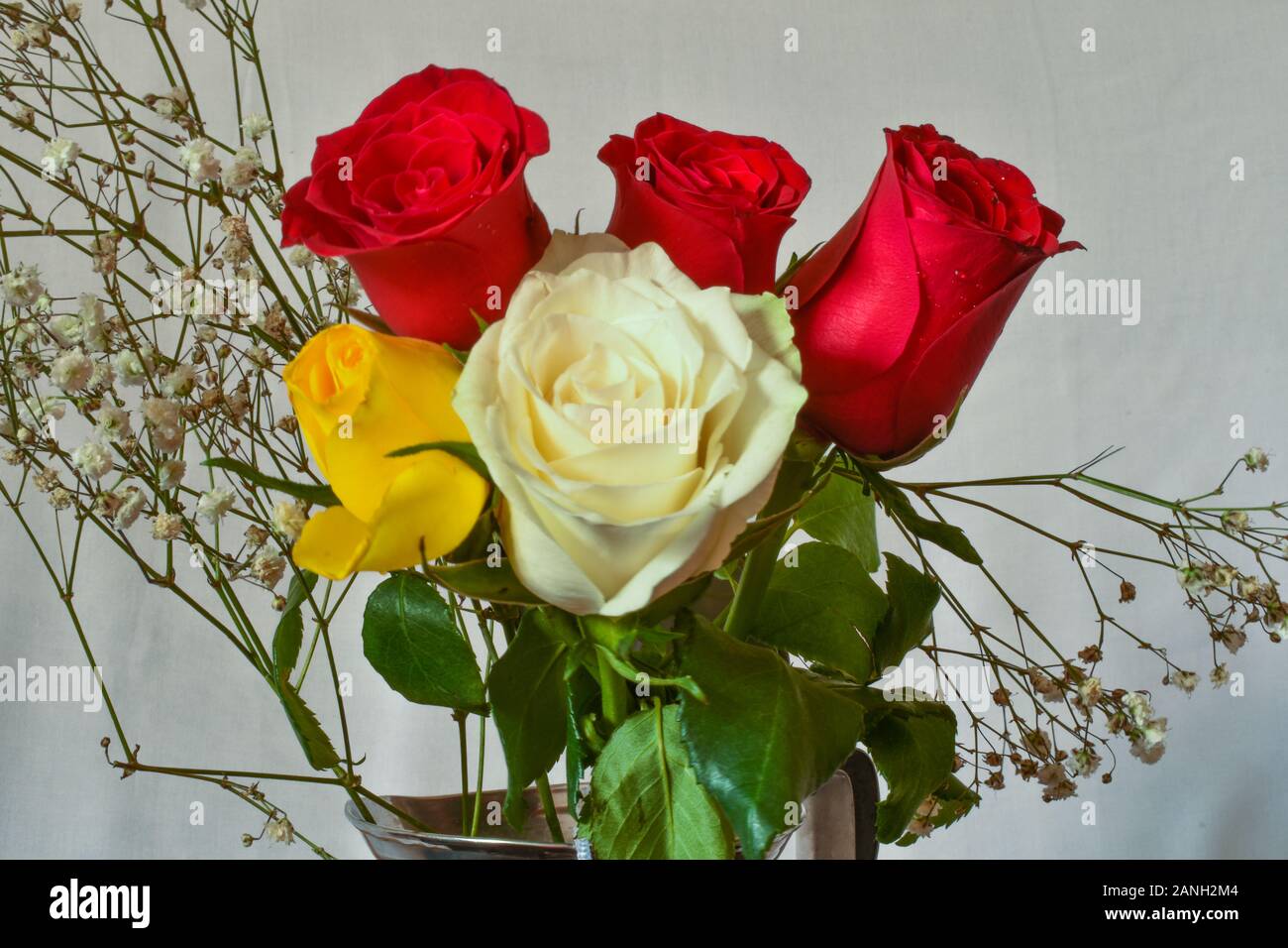 a bouquet of red yellow and white roses in a vase Stock Photo - Alamy