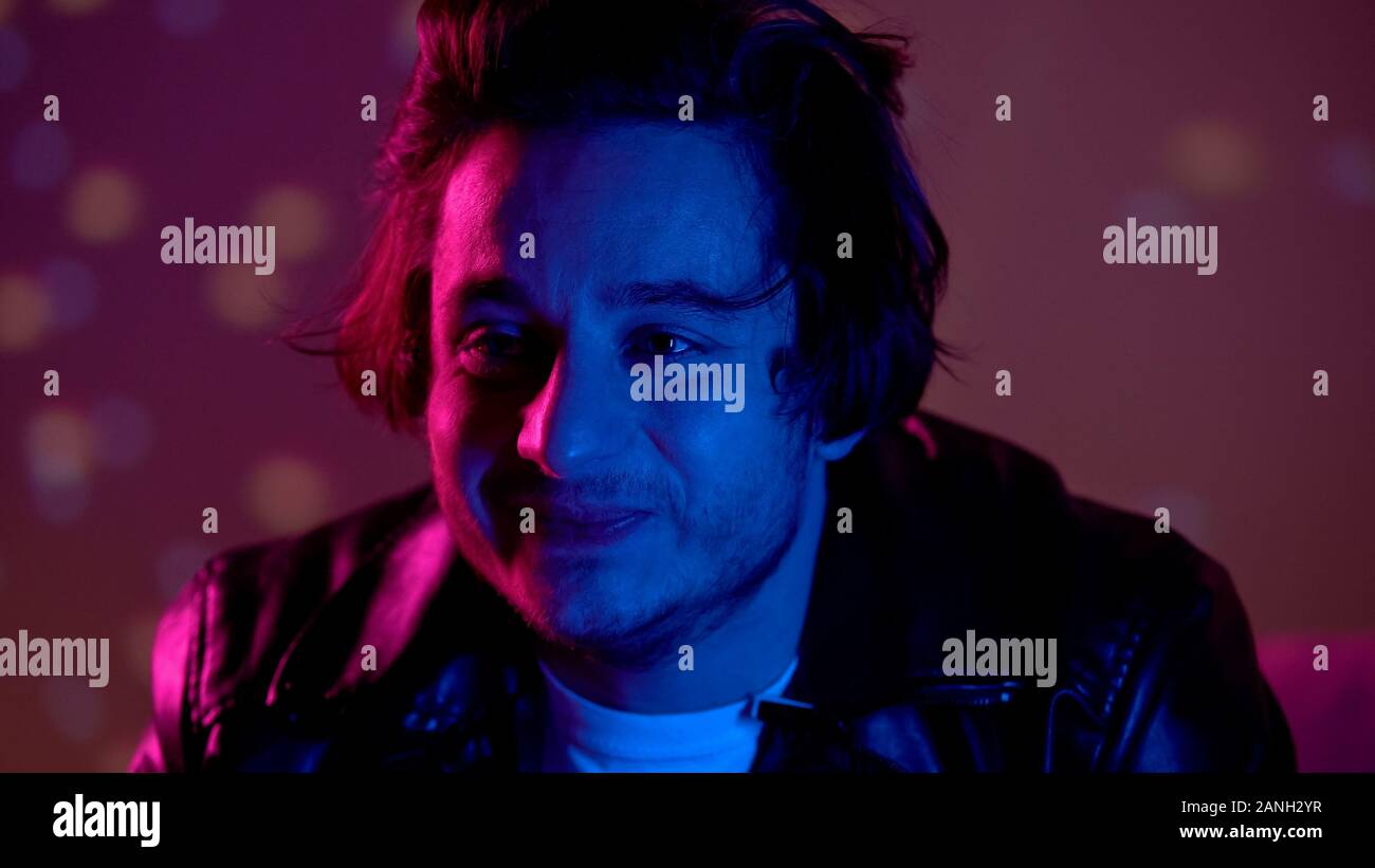 Drunk man smiling in night club, relieving stress after busy working ...