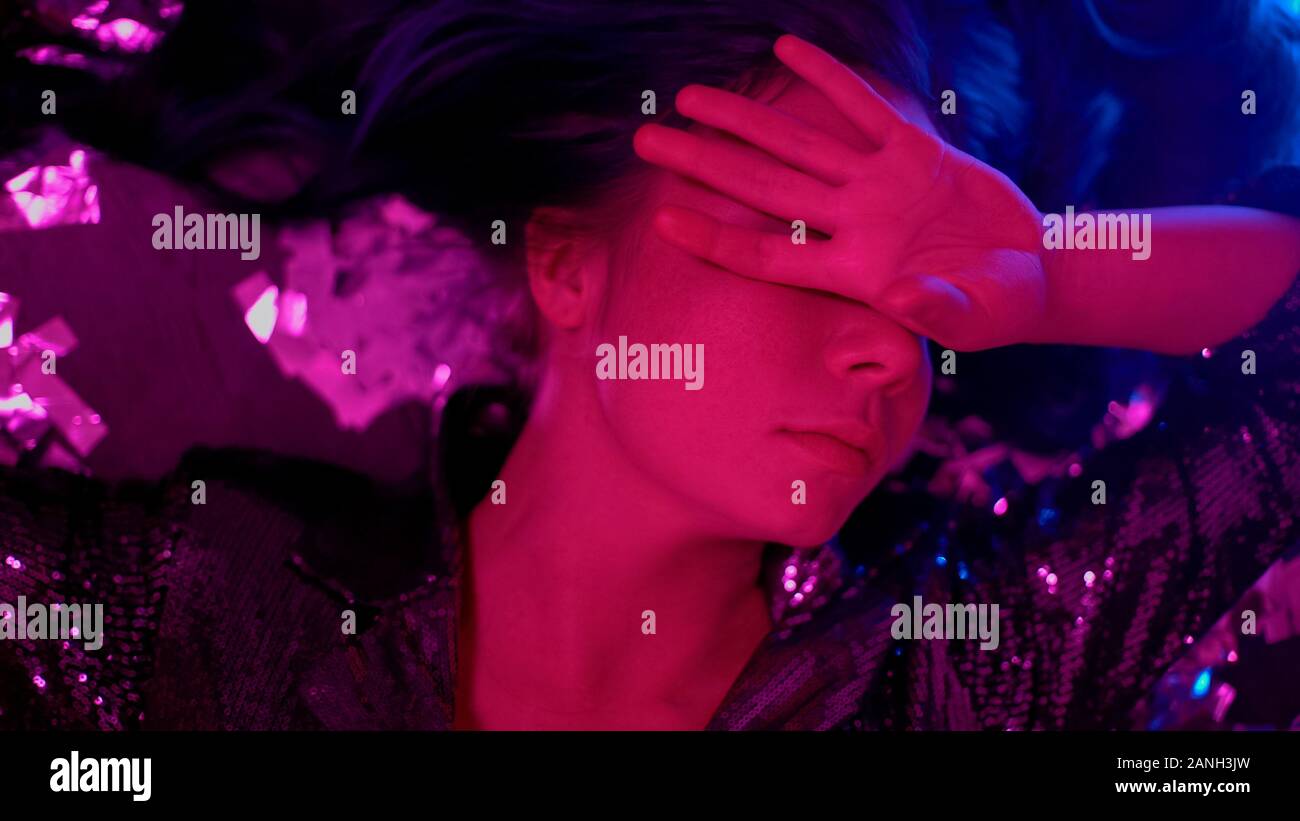 Drunk girl awakening on floor after party, feeling dizzy and sick, top ...