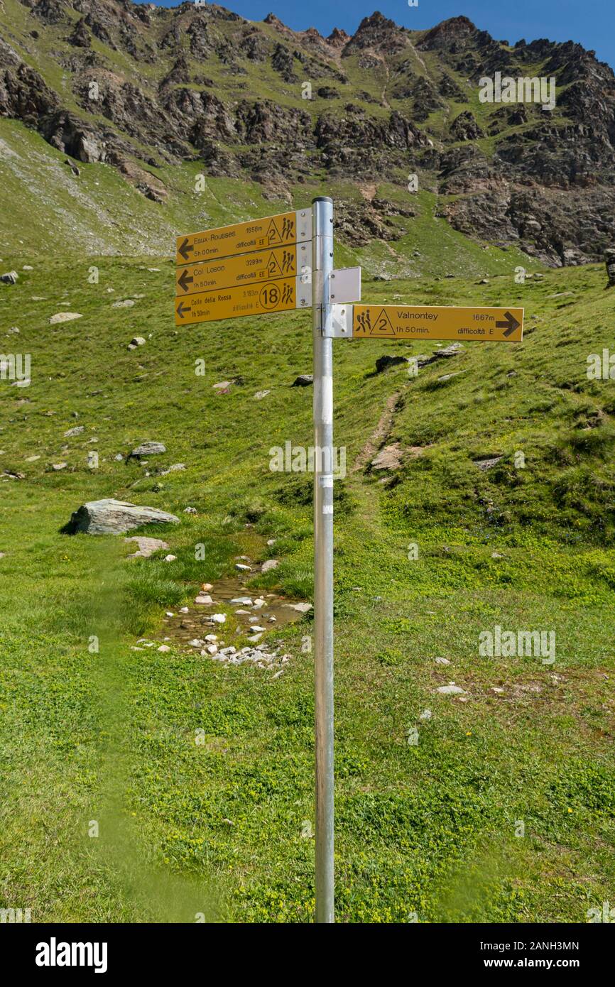 Yellow sign post indicating different hiking trails above Valnontey ...