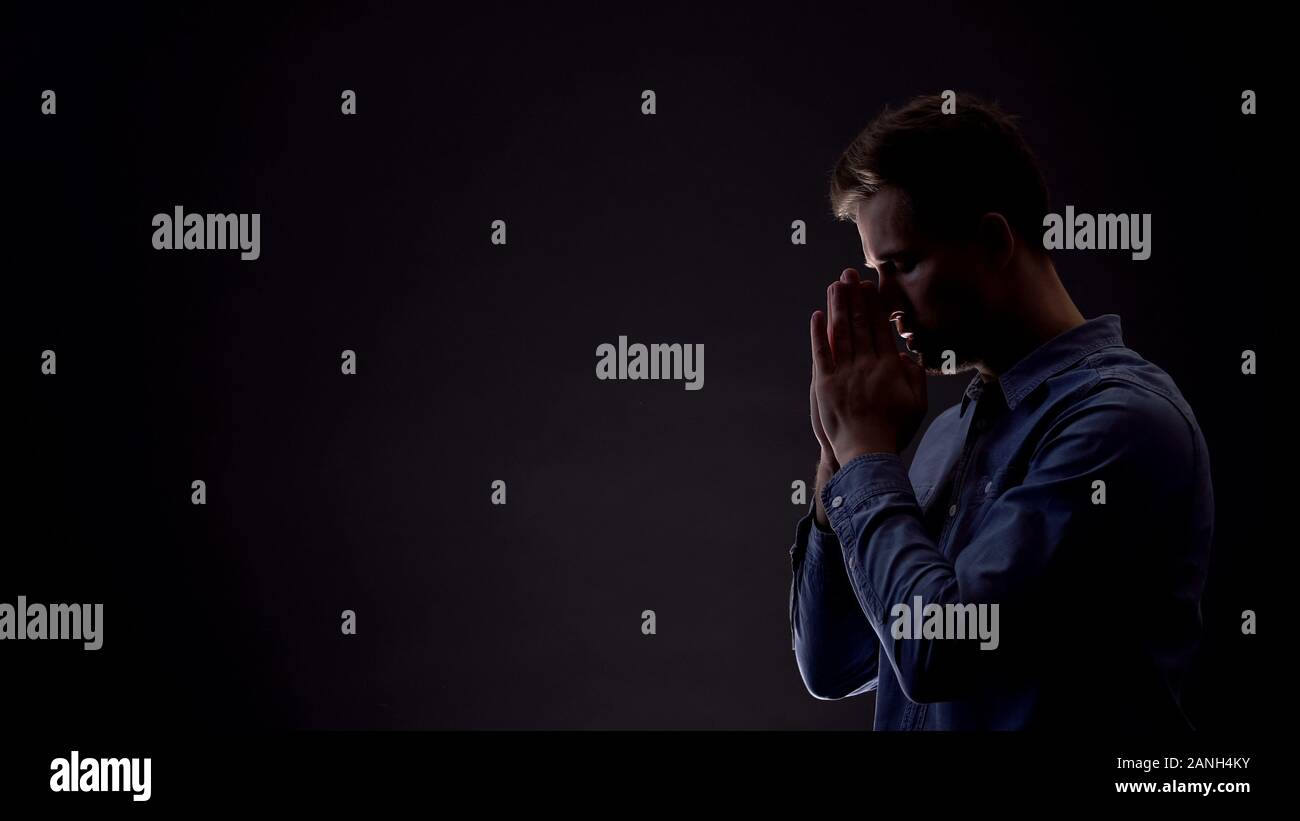 Sinner praying to God in dark room, asking for forgiveness, confession ...