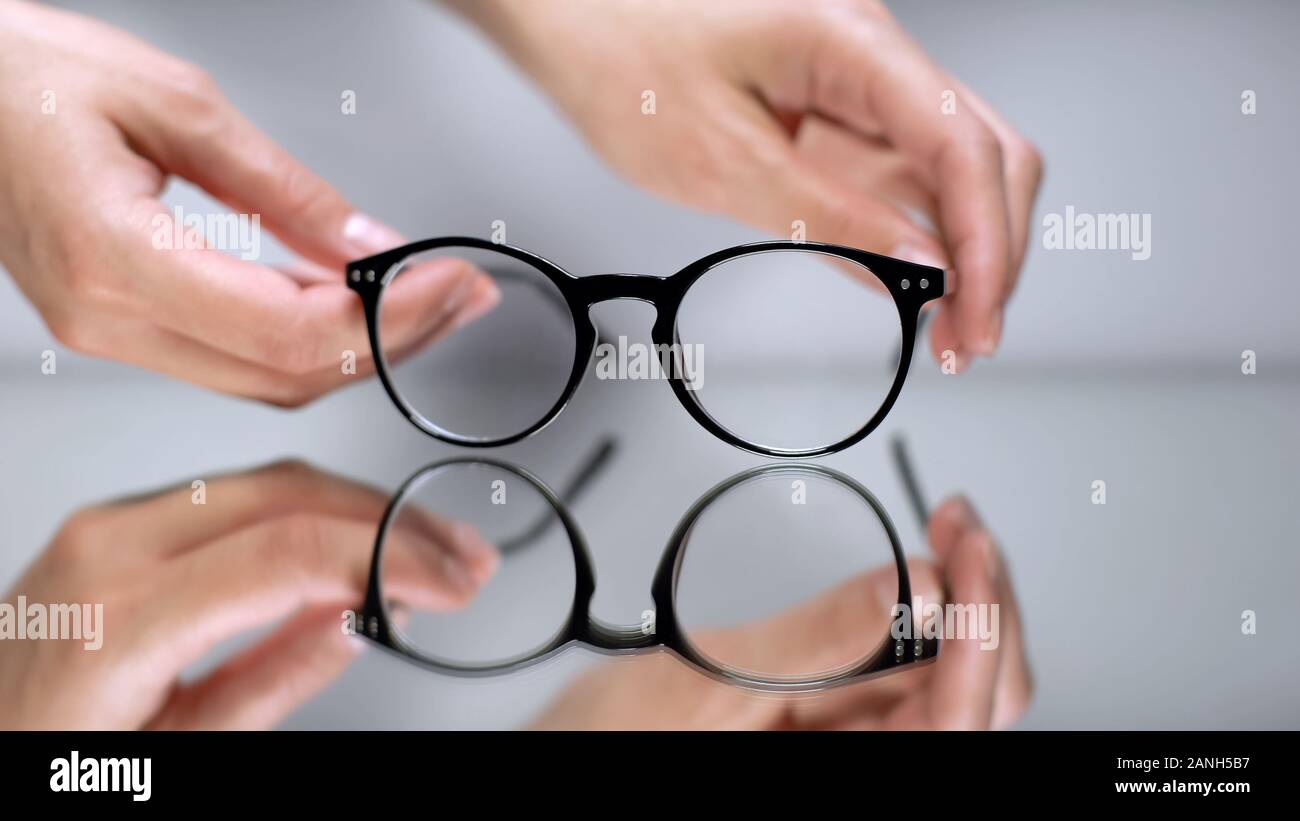 Female hands taking corrective eyeglasses prescribed by optometrist ...