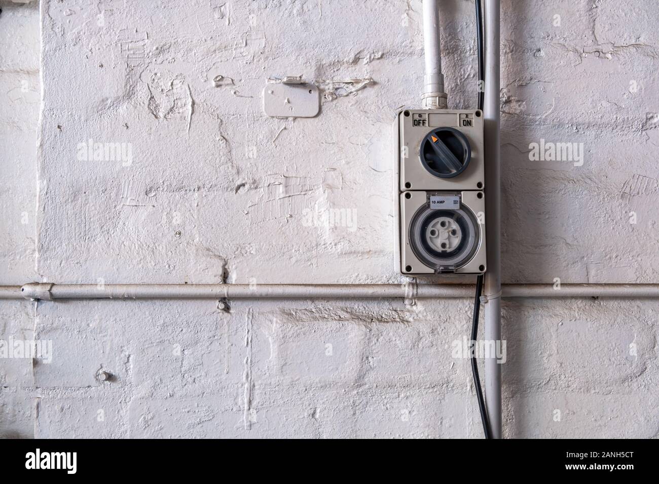 Industrial 10 amper power outlet mounted to a workshop wall with copy ...