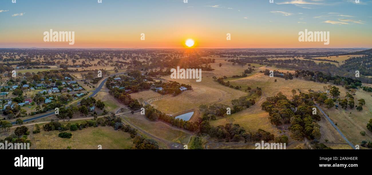 Sun touching the horizon at sunset over Australian outback - wide ...